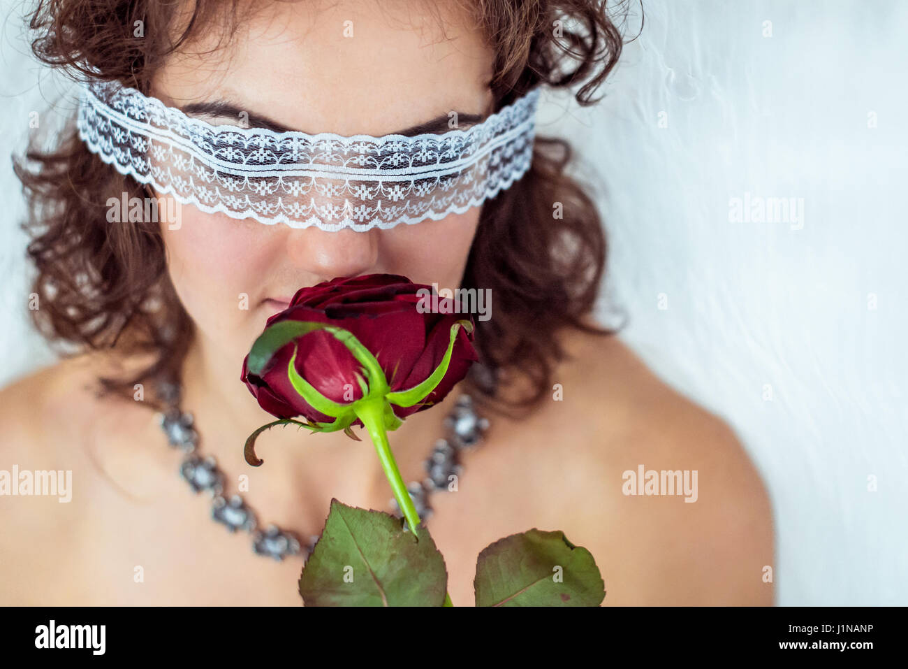 Beautiful woman smells red rose Stock Photo - Alamy
