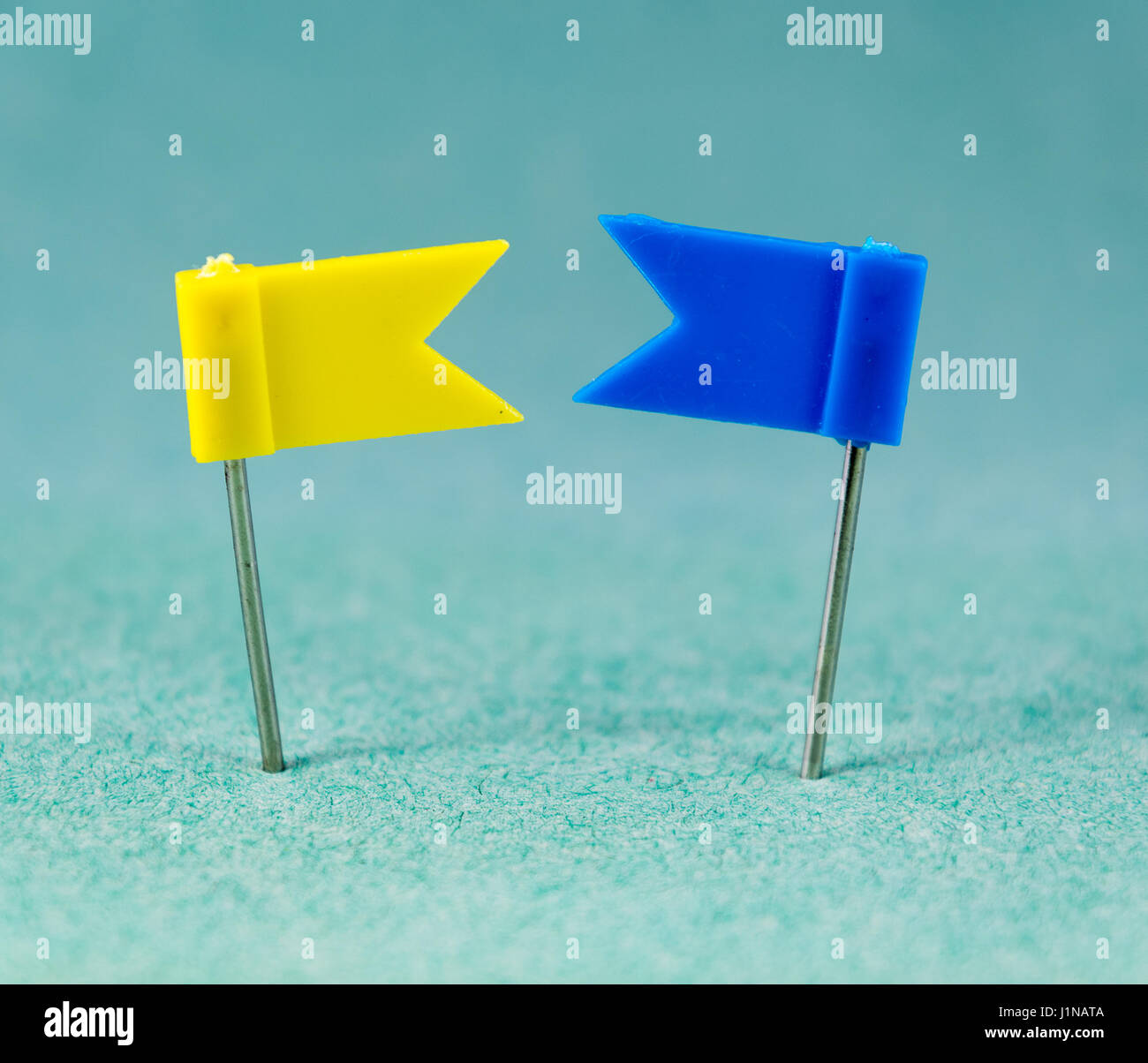 Yellow and Blue flag pins on a green background Stock Photo - Alamy