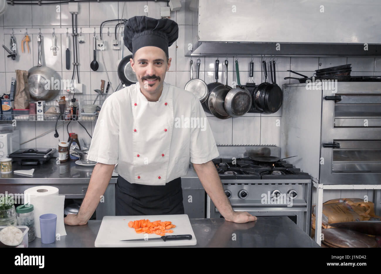 one young adult man chef smiling happy posing, looking at camera ...