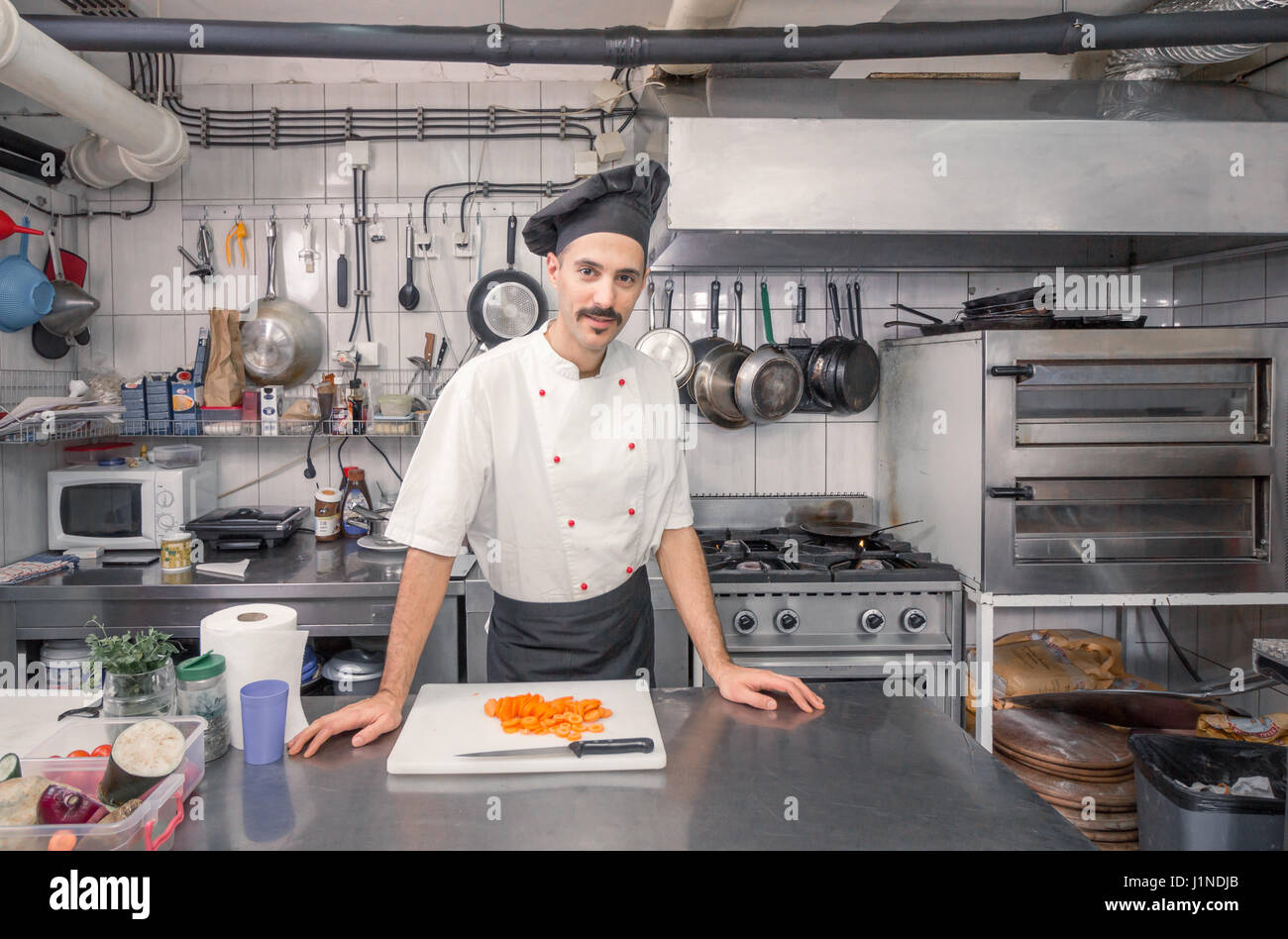 One young adult man handsome young chef, commercial kitchen ...