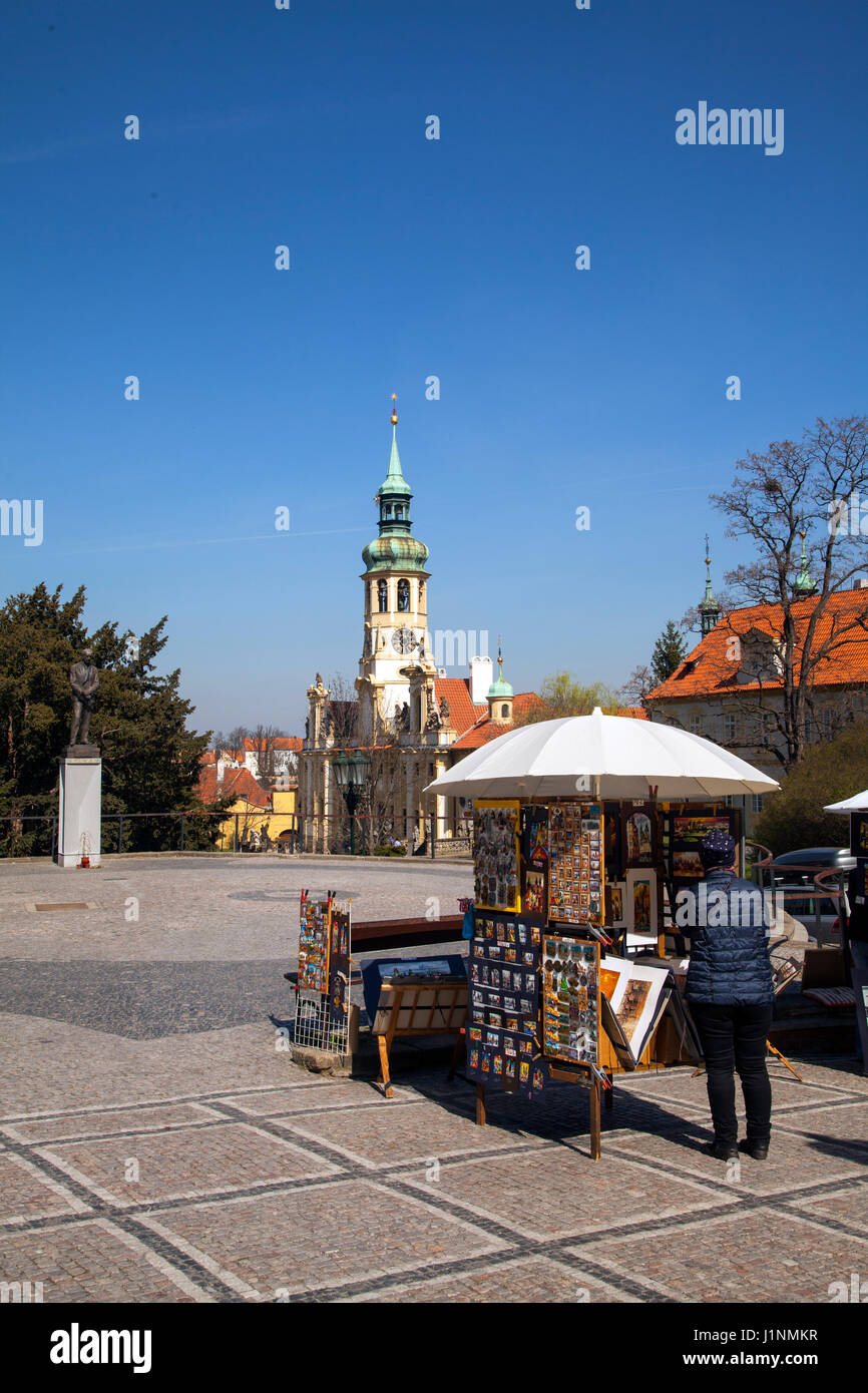 Street vendor in The Loreta square Prague with the Loreta church in the ...