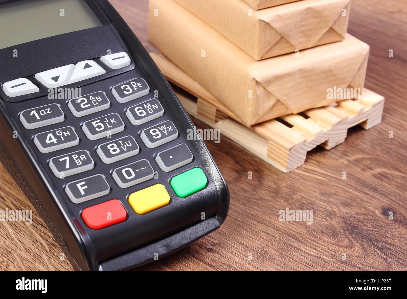 Payment terminal and small wrapped boxes on wooden pallet, concept of ...