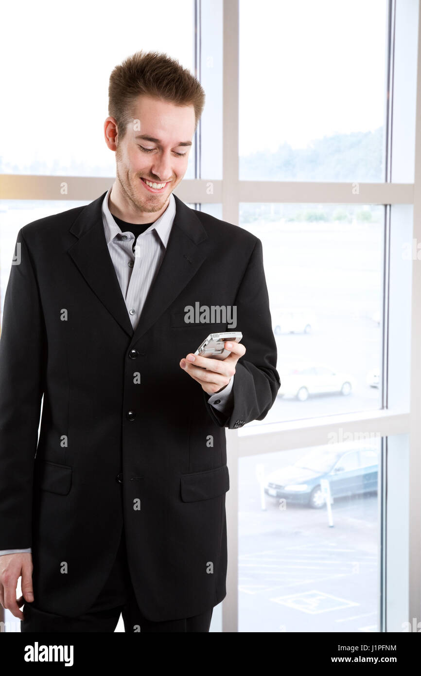 A happy caucasian businessman receiving a text message Stock Photo - Alamy