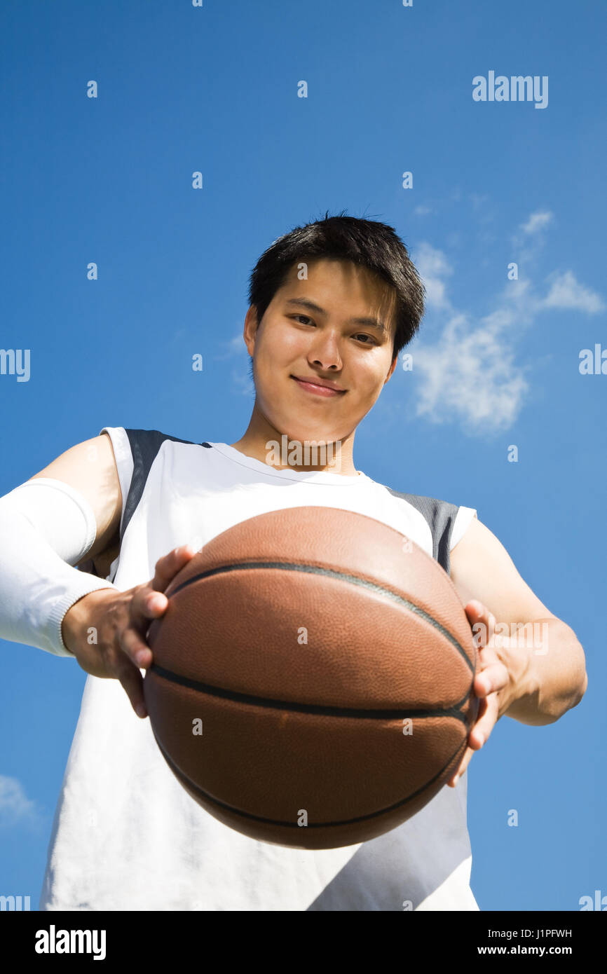 A happy asian basketball player holding a basketball Stock Photo - Alamy
