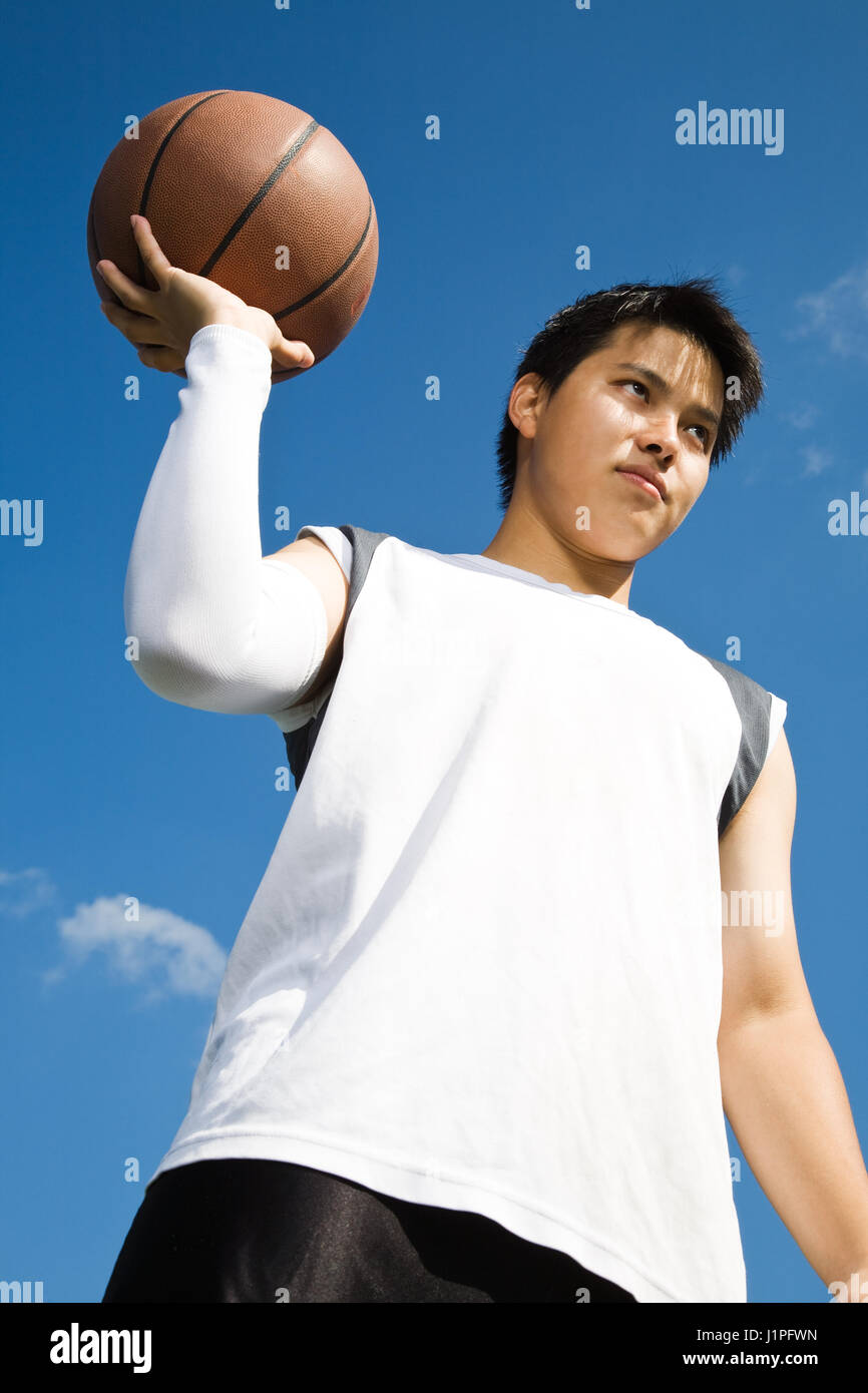 A shot of an asian basketball player holding a basketball Stock Photo ...