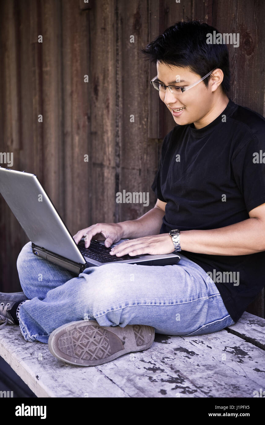 A happy asian college student working on his laptop Stock Photo - Alamy