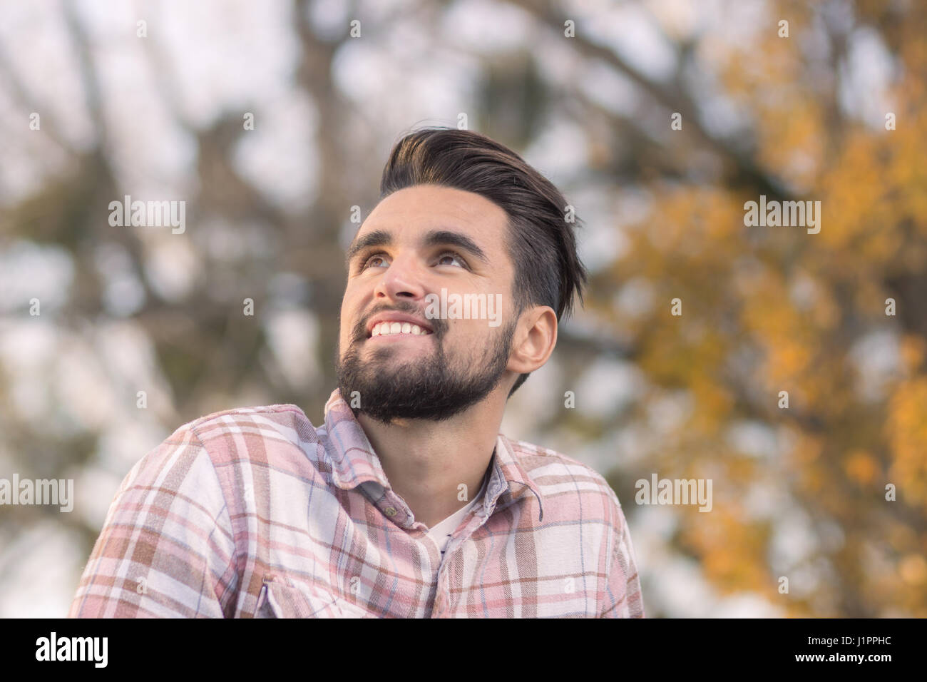 Young man smiling looking up head face, close up, low angle shot ...