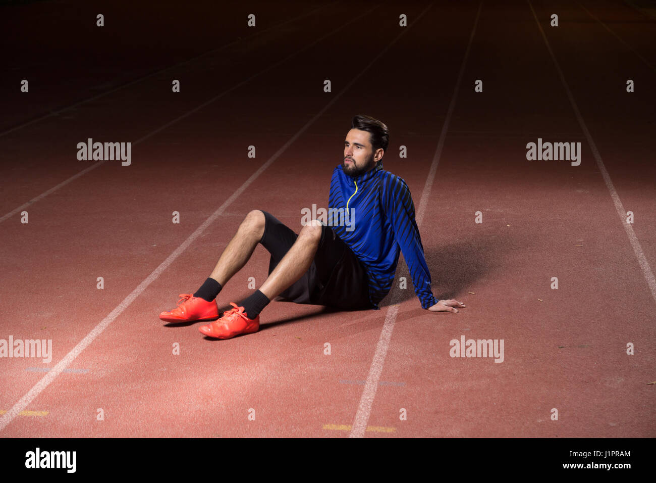 One young adult man, athlete, sporting, runner, relaxing at running ...