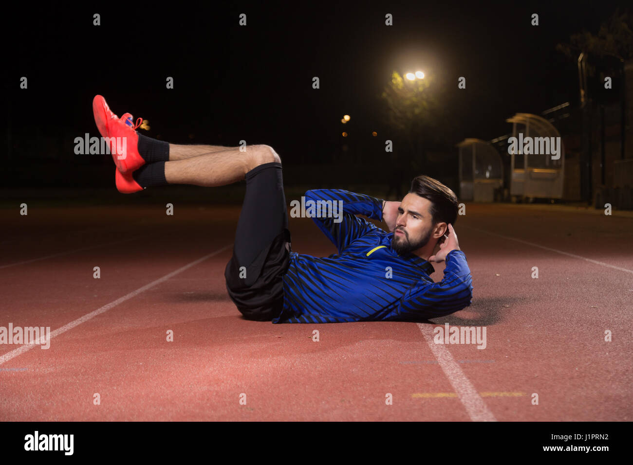 One young adult man, athlete, core side abs exercise. Night dark ...