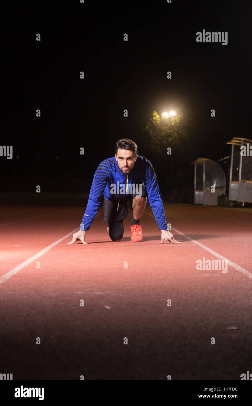 Runner, sprinter, athlete start position, running tracks. looking at ...