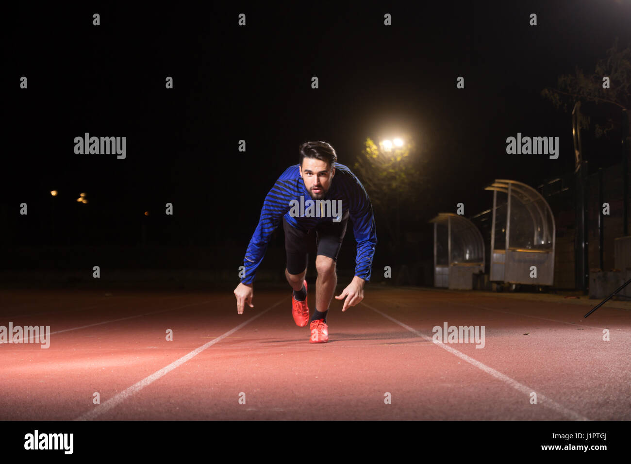 sprinter, sprinting, start position. running track, night, dark Stock ...