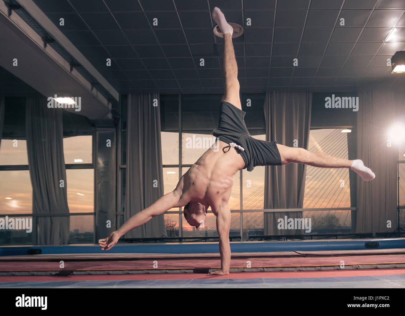 Young fit muscular athletic adult man, Young man one hand cartwheel ...