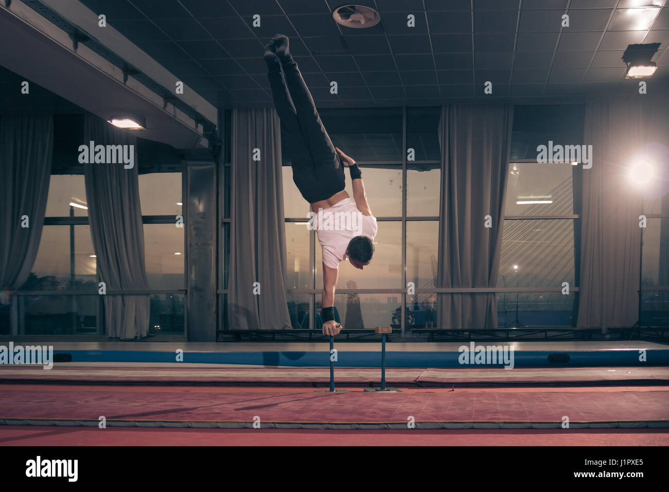 Young adult muscular man, one one hand cartwheel, large hall Stock ...