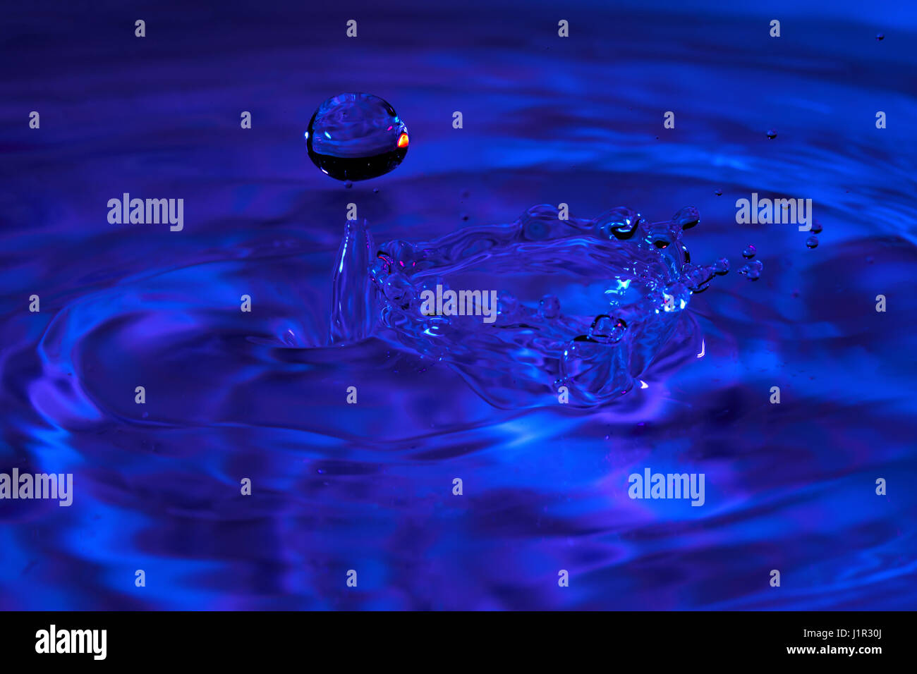 drop falls into the water rising wave Stock Photo - Alamy