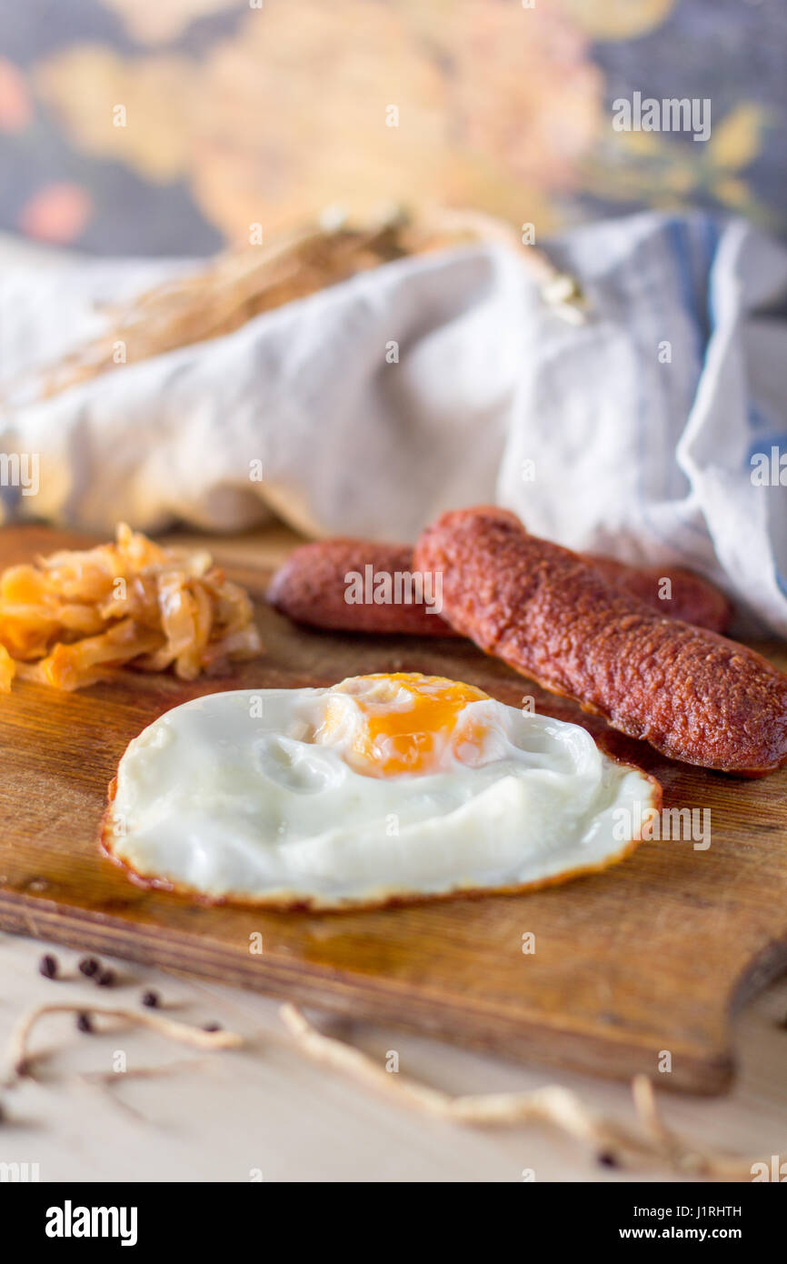 fried eggs with sausages and fried cabbage, rustic Stock Photo - Alamy