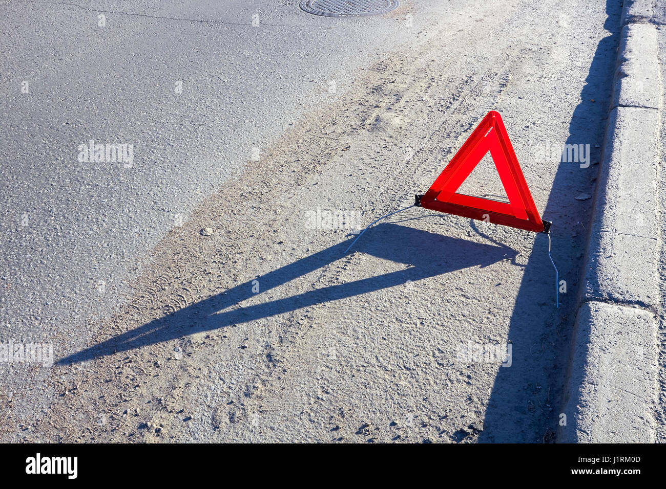 Red warning triangle on street Stock Photo - Alamy