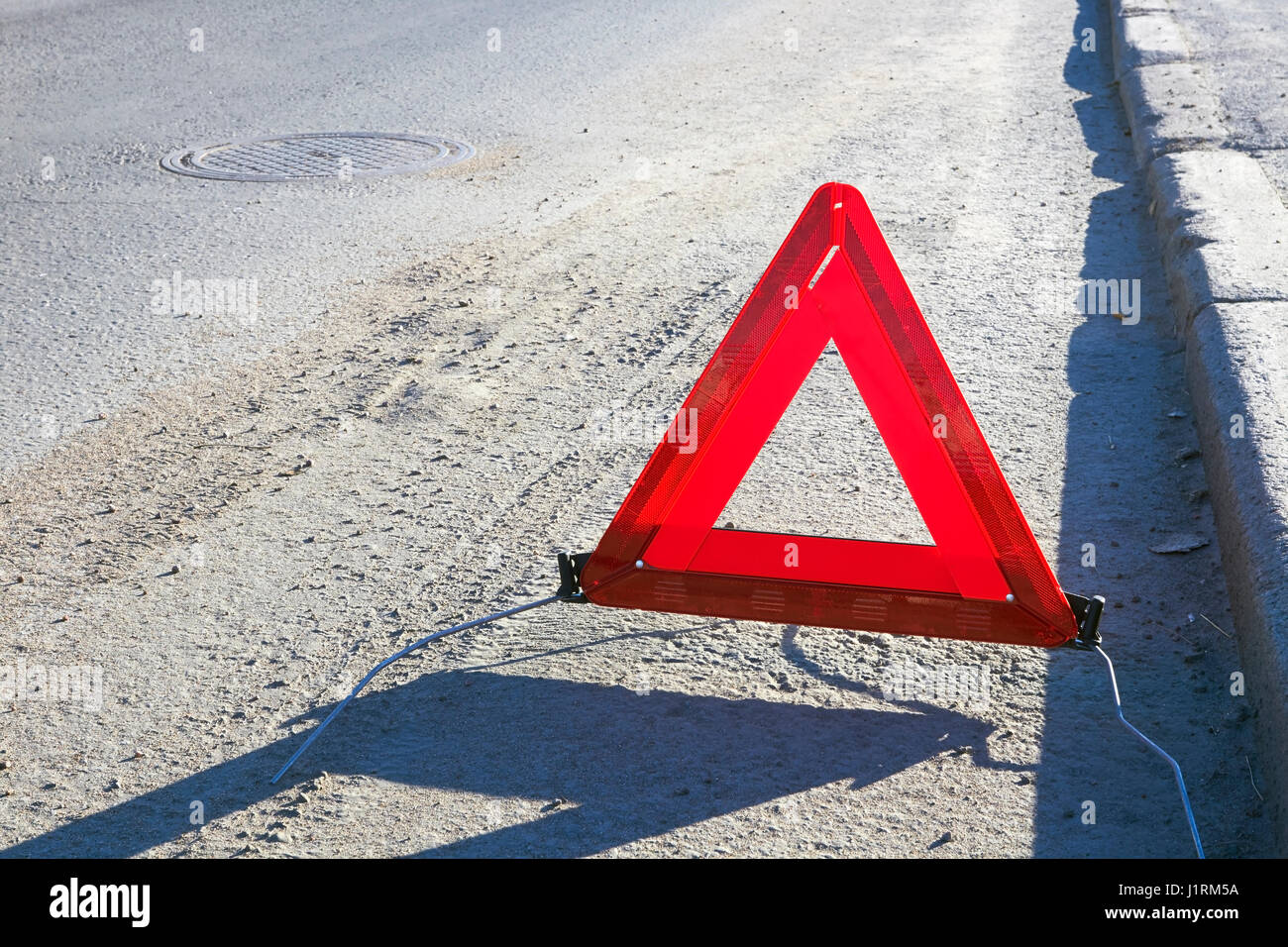 Red warning triangle on street Stock Photo - Alamy