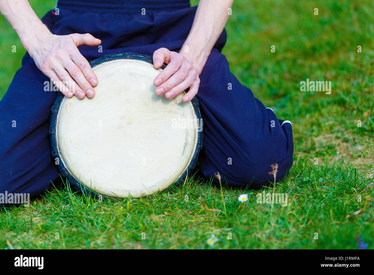 Drummer man with her djembe drum on meadow Stock Photo - Alamy