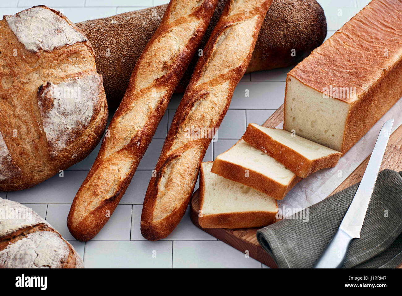 Multiple loaf of breads and sandwich on white table Stock Photo - Alamy