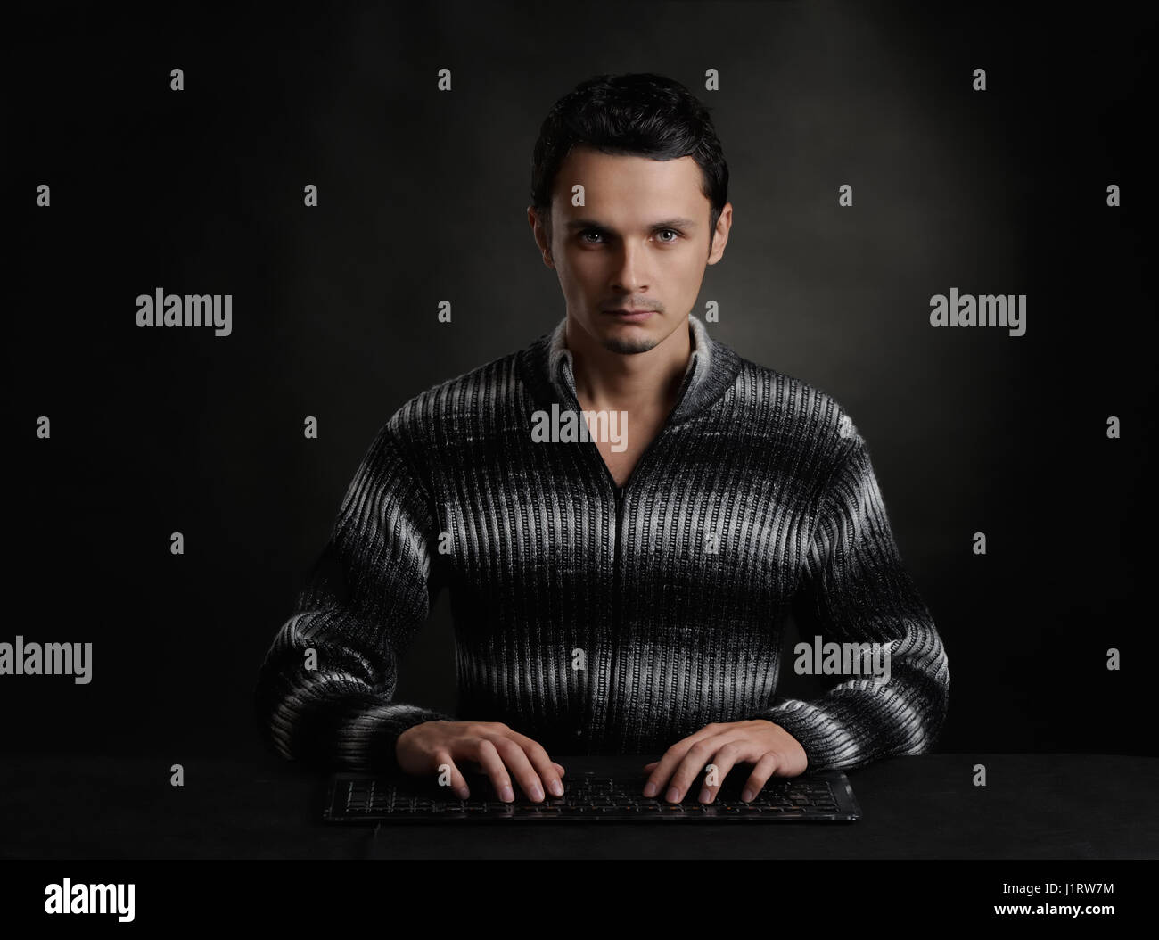 Man with keyboard on black background Stock Photo - Alamy