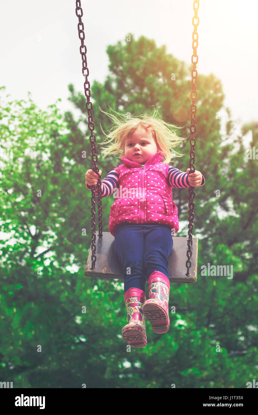 Toddler girl on the swing Stock Photo - Alamy