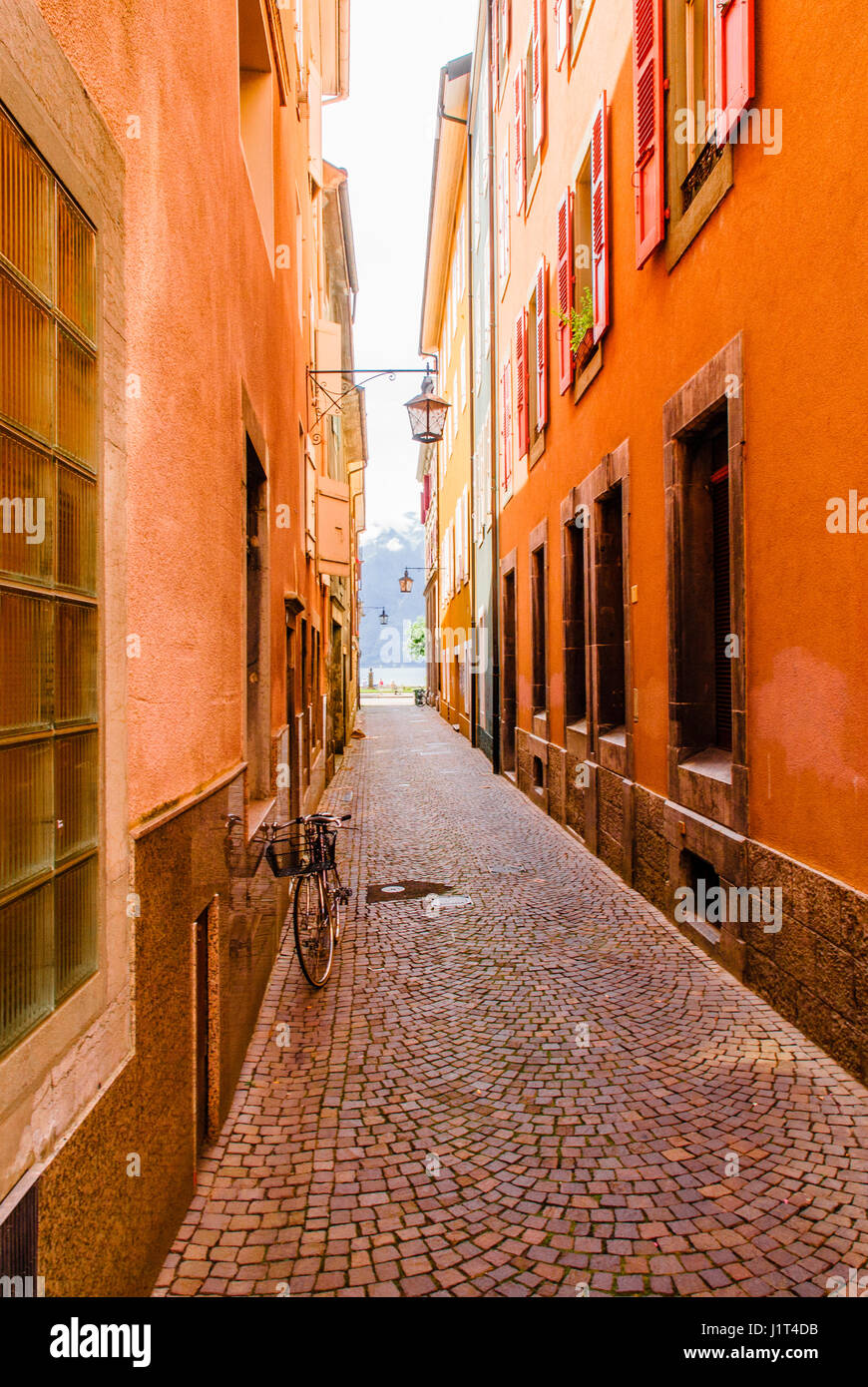 A bicycle resting on a wall in an alley way in Vevey, Switzerland Stock ...