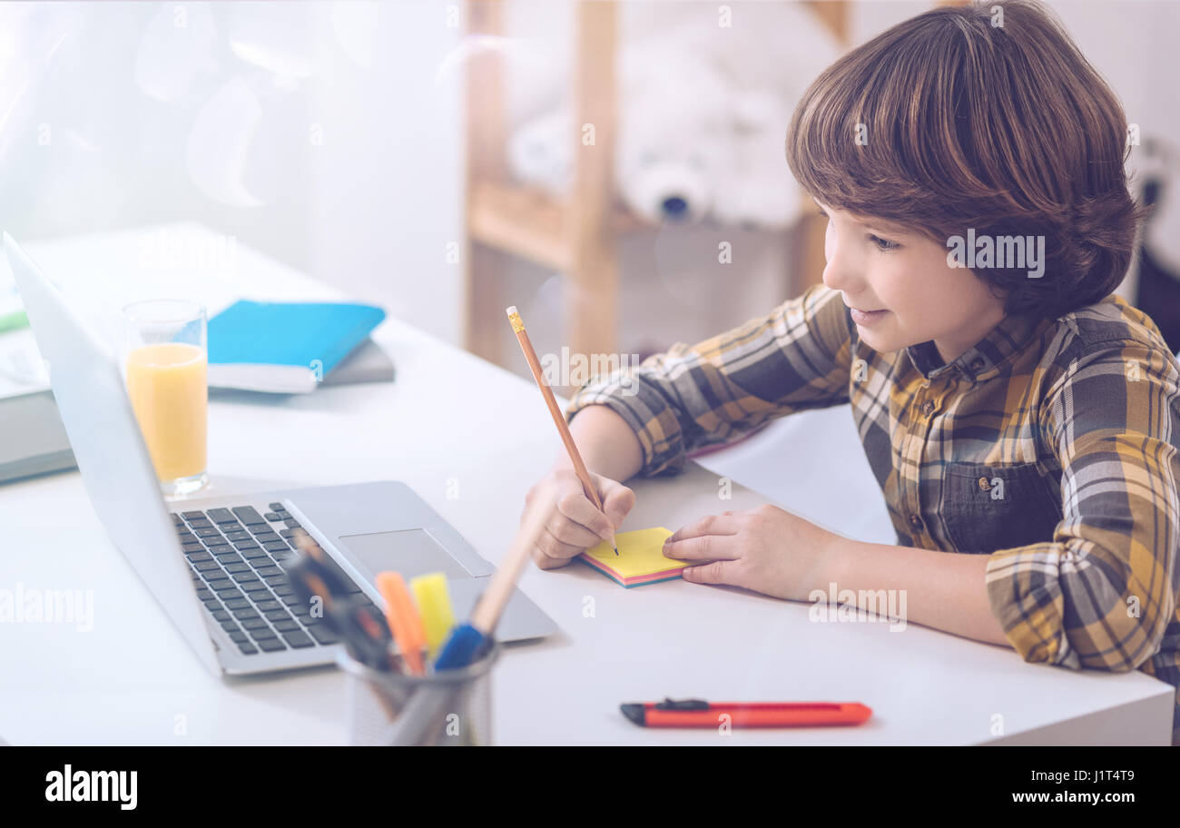 Beautiful little boy writing down notes Stock Photo - Alamy