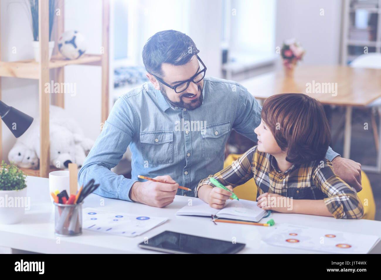 Positive father and son working on project together Stock Photo - Alamy