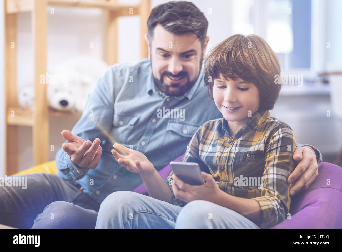 Father and son looking at cell phone together Stock Photo - Alamy