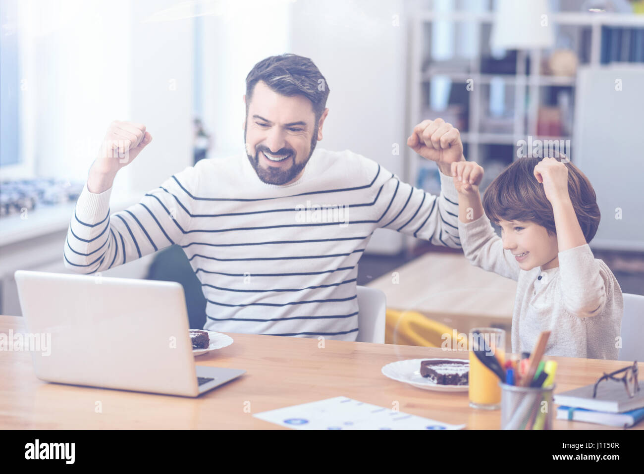 Emotional father and son rejoicing over victory Stock Photo - Alamy