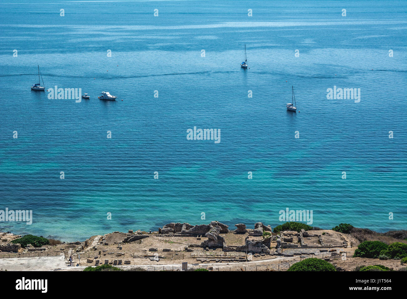 Beautiful turquoise sea with yachts and small part of Corinthian ruins ...