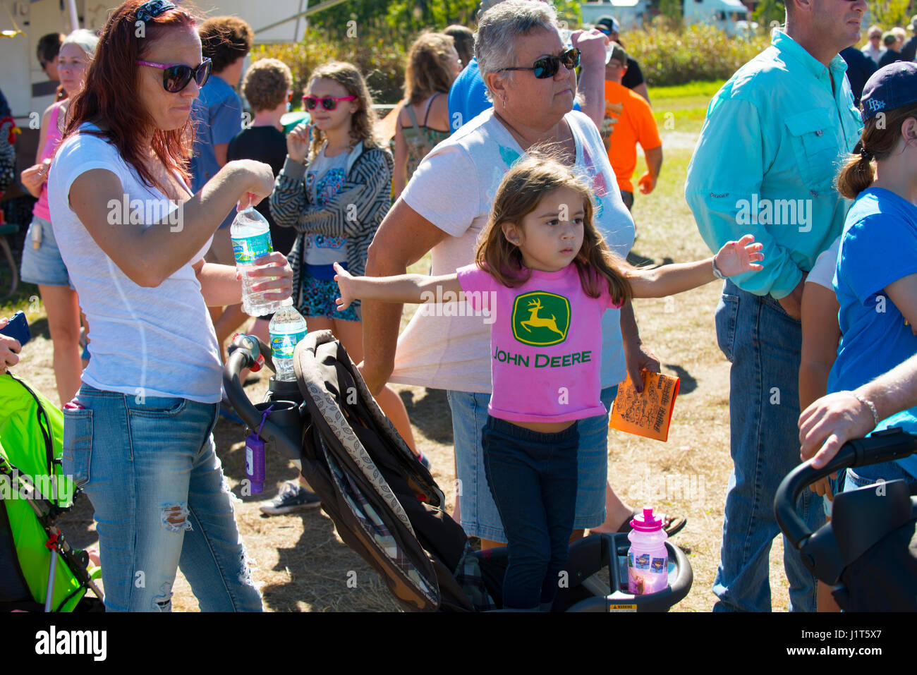 people at a fair little girl and family Stock Photo - Alamy