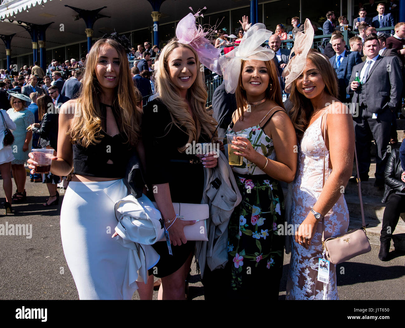 Racegoers pose for a photographer during Coral Scottish Grand National ...