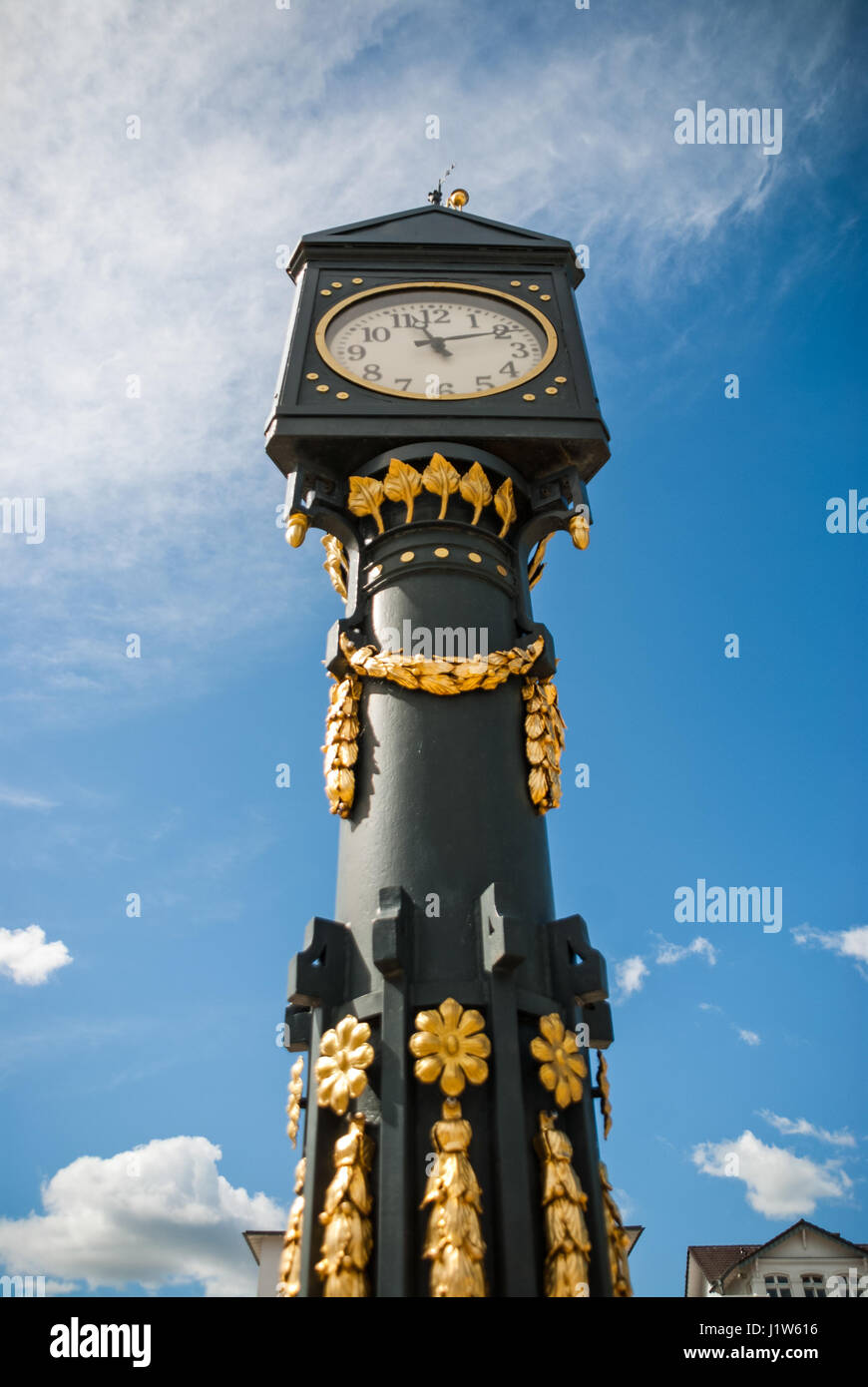 An old golden clock Tower in front of a church Stock Photo - Alamy
