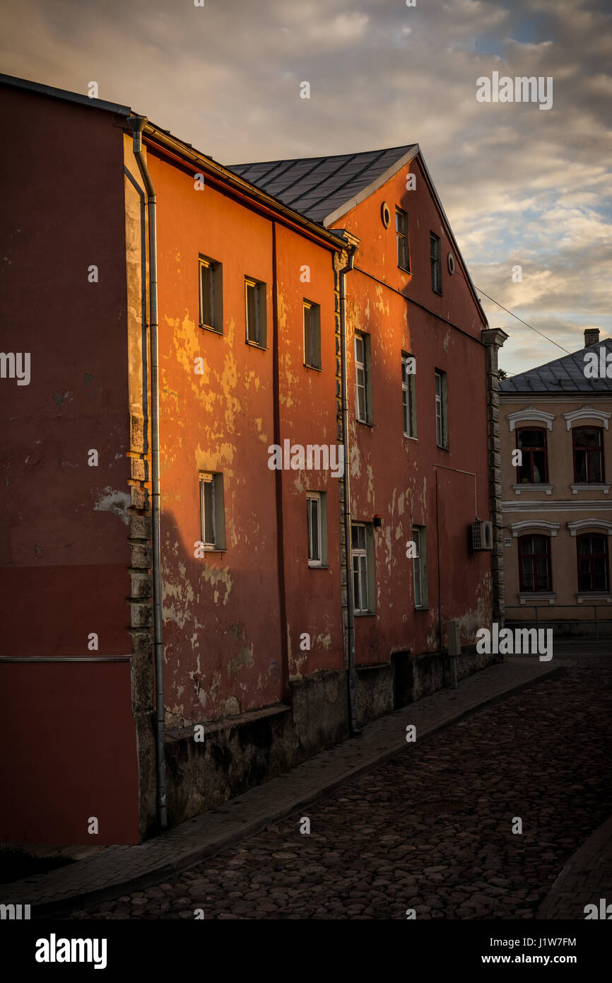 Red house in the old town of Jekabpils, Latvia with sun beams on it and ...