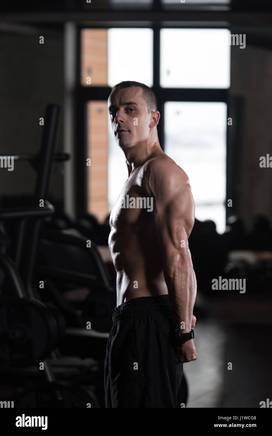 Healthy Man Standing Strong In The Gym And Flexing Muscles - Muscular ...