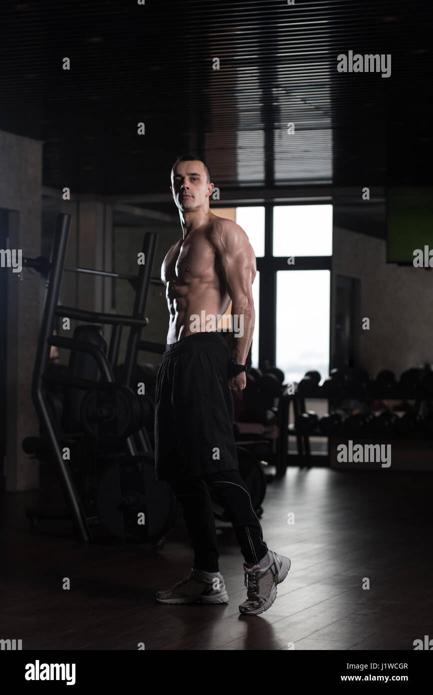 Healthy Man Standing Strong In The Gym And Flexing Muscles - Muscular ...