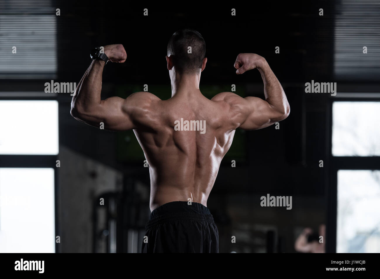 Healthy Man Standing Strong In The Gym And Flexing Muscles - Muscular ...