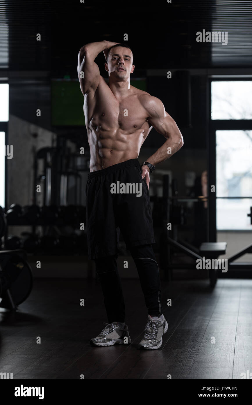 Healthy Man Standing Strong In The Gym And Flexing Muscles - Muscular ...