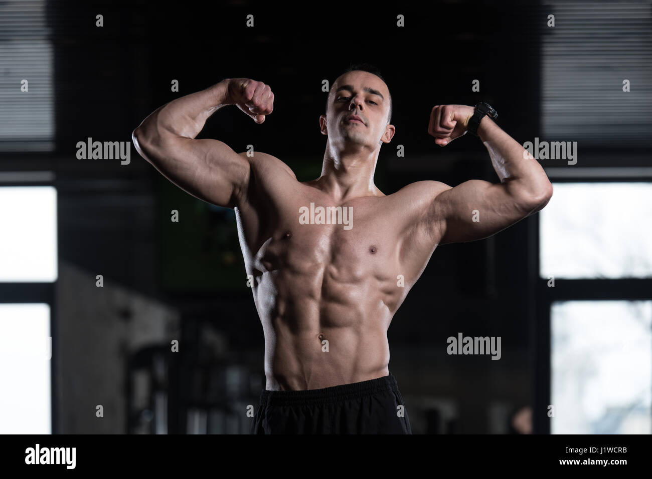 Healthy Man Standing Strong In The Gym And Flexing Muscles - Muscular ...