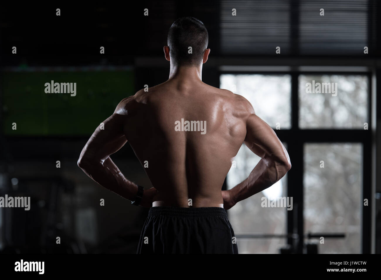 Handsome Man Standing Strong In A Modern Gym And Flexing Muscles ...