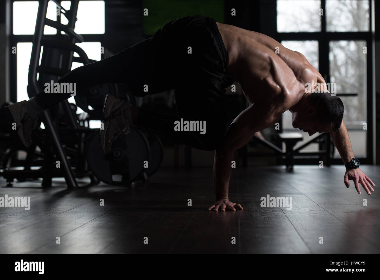 Young Man Athlete Doing Extreme Handstand On One Hand As Part Of ...