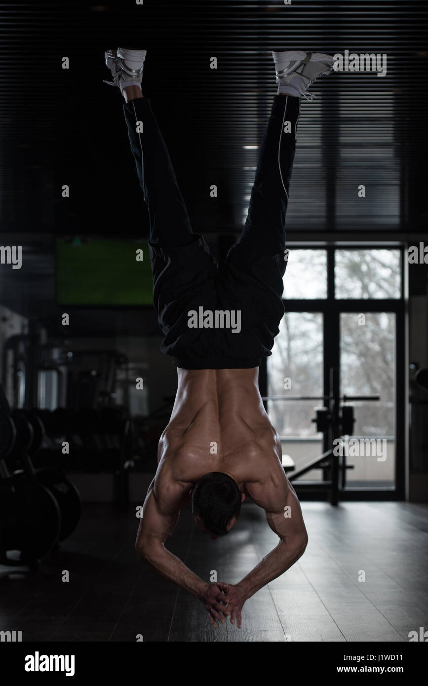 Young Man Athlete Doing Extreme Pushups Handstand As Part Of ...