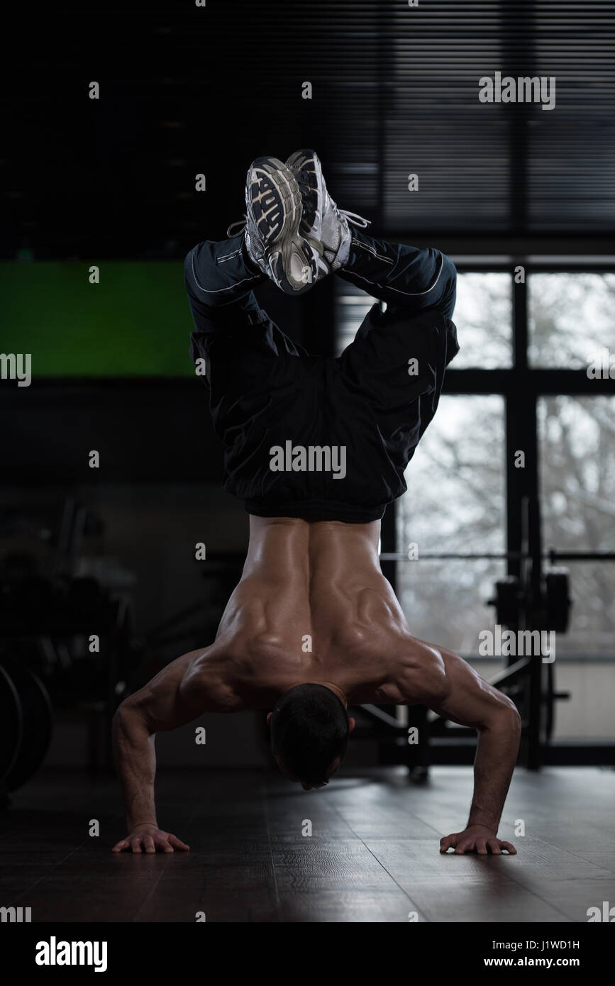 Young Man Athlete Doing Extreme Pushups Handstand As Part Of ...