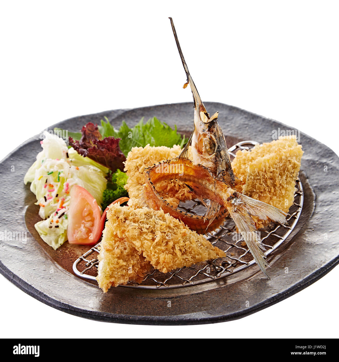 Deep fried fish on black dish with tomato and lettuce salad Stock Photo ...