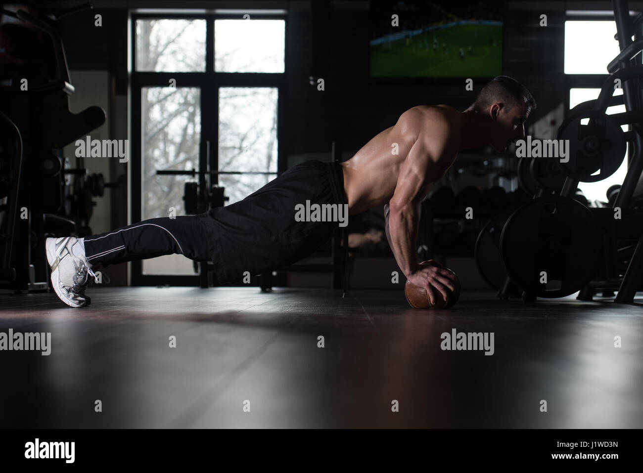 Young Man Athlete Doing Pushups On Ball With One Hand As Part Of ...