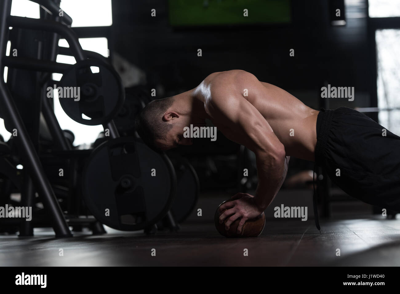 Young Man Athlete Doing Pushups On Ball With One Hand As Part Of ...