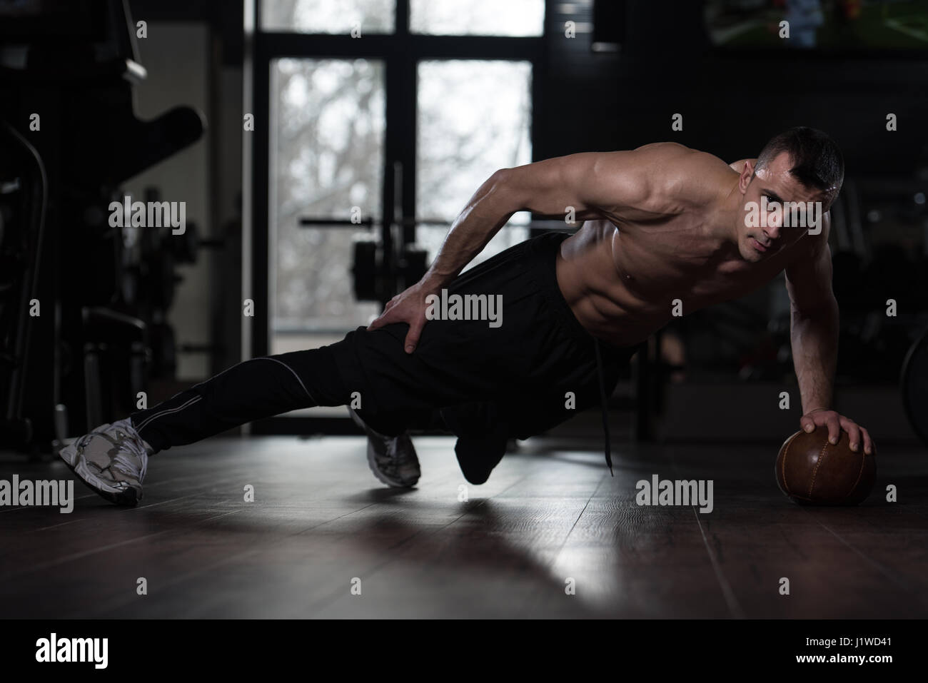 Young Man Athlete Doing Pushups On Ball With One Hand As Part Of ...