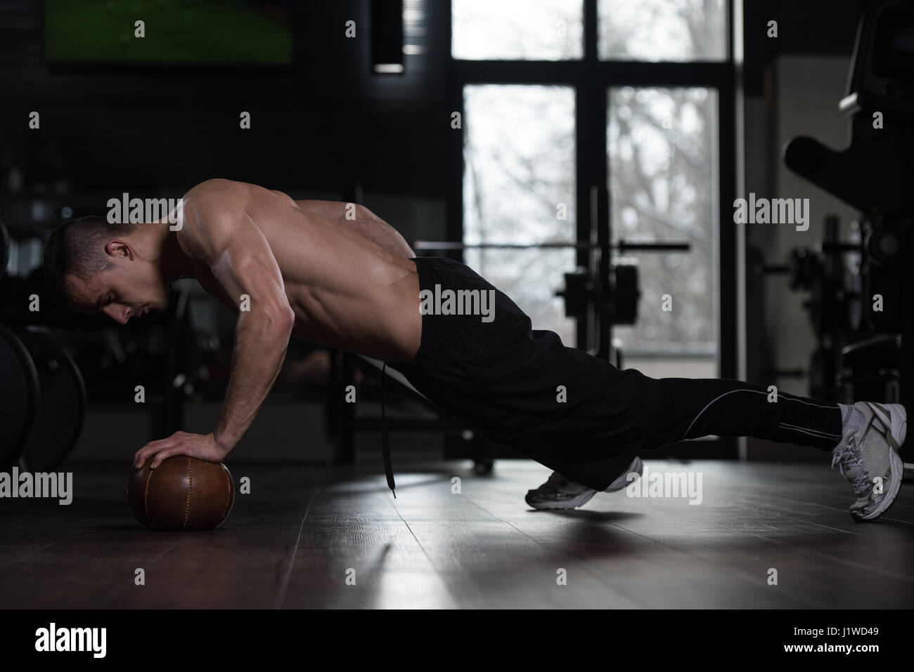 Young Man Athlete Doing Pushups On Ball With One Hand As Part Of ...