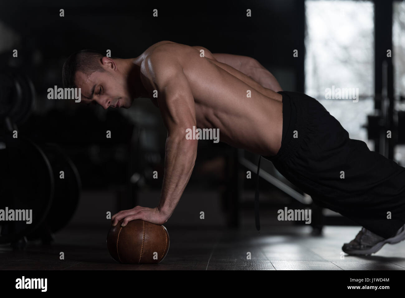 Young Man Athlete Doing Pushups On Ball With One Hand As Part Of ...